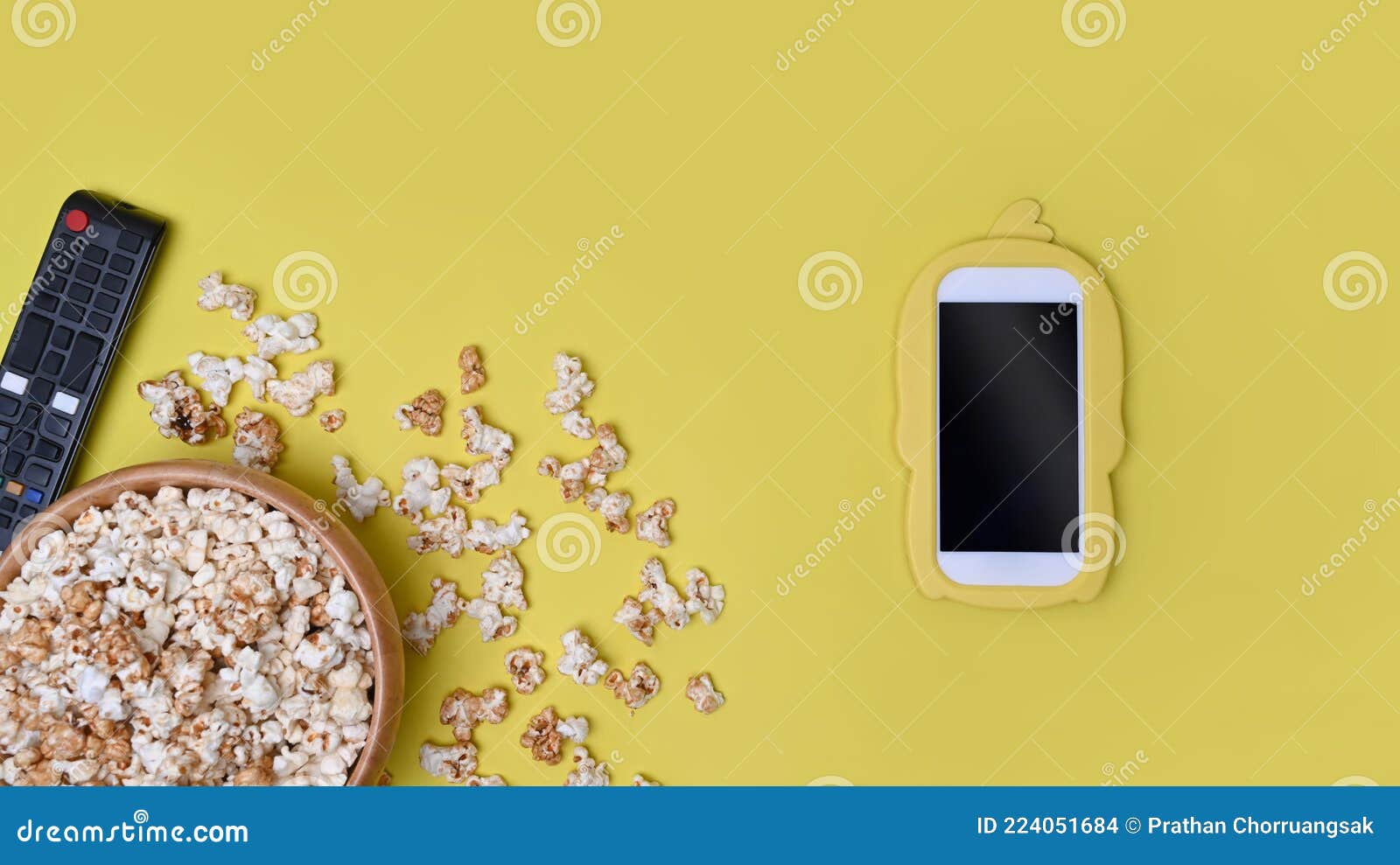 Bowl of Popcorn, Remote Control and Mobile Phone on Yellow Background ...