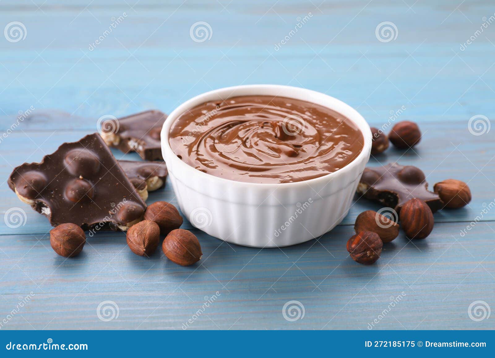 Bowl with Tasty Paste, Chocolate Pieces and Nuts on Light Blue Wooden ...