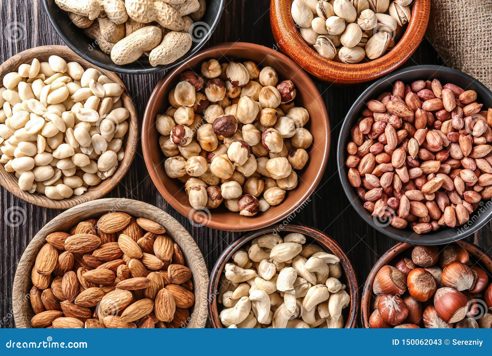 Bowls with Different Nuts on Wooden Table, Top View Stock Image - Image ...