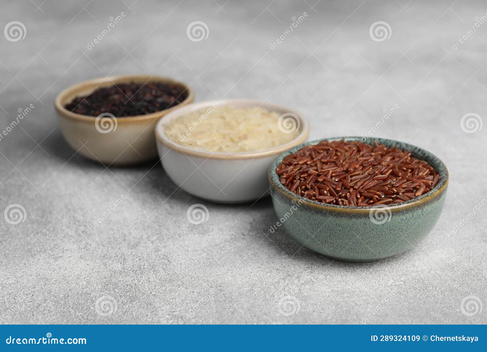 Bowls with Different Sorts of Rice on Grey Table Stock Image - Image of ...