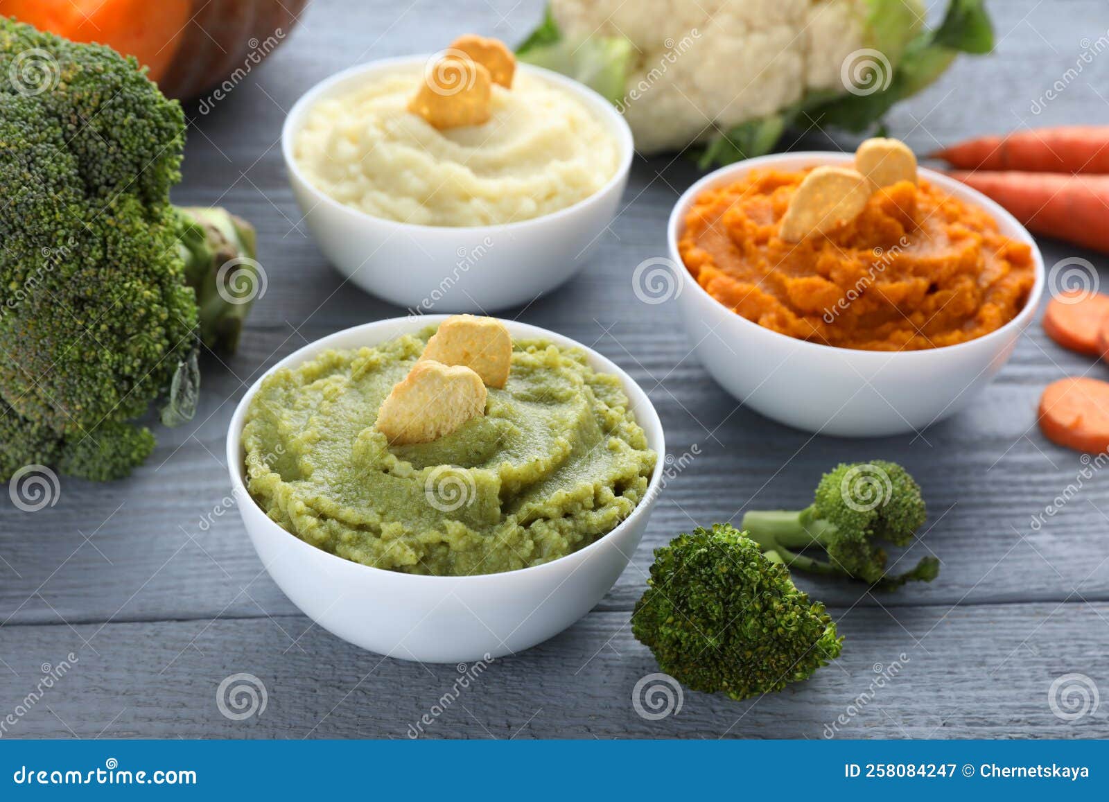 Bowls with Different Tasty Puree and Ingredients on Light Blue Table ...