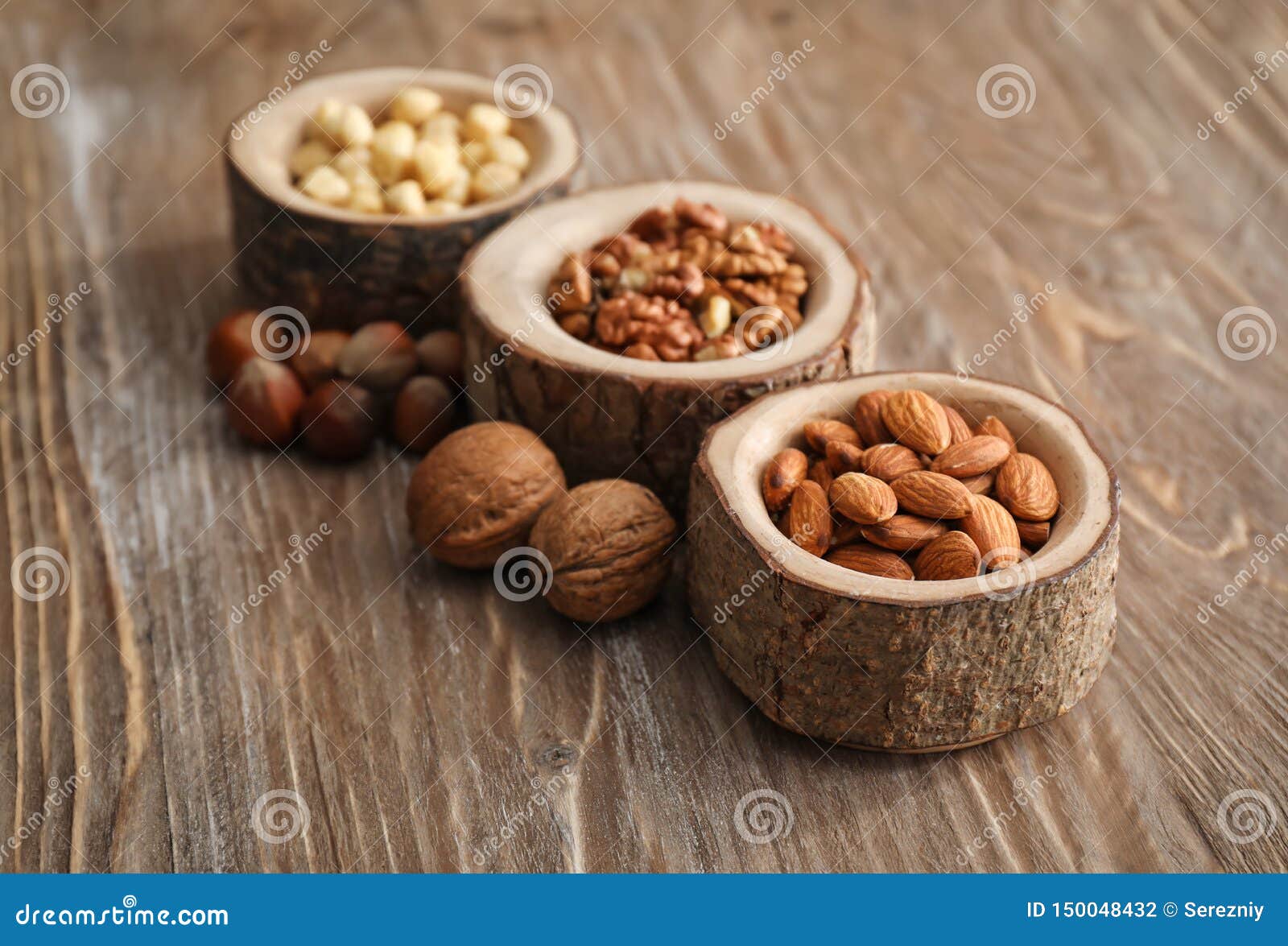 Bowls with Various Tasty Nuts on Wooden Table Stock Photo - Image of ...