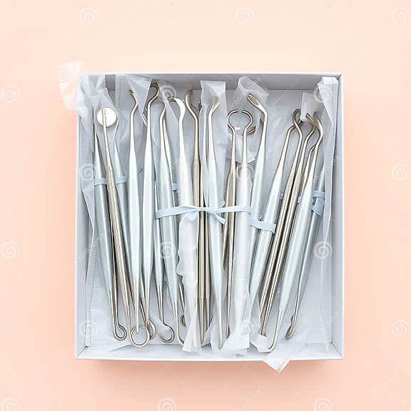 A Box of Individually Wrapped Dental Instruments on a Pastel Peach ...