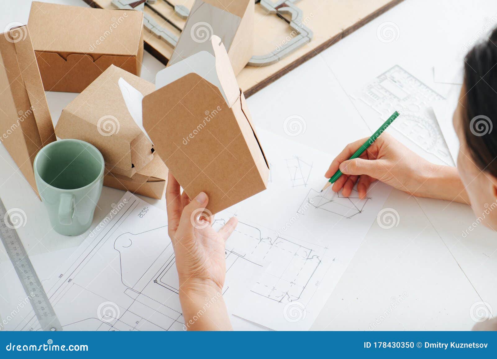 Box Maker Working Behind a Table, Holding Box in Her Hand Stock Photo ...