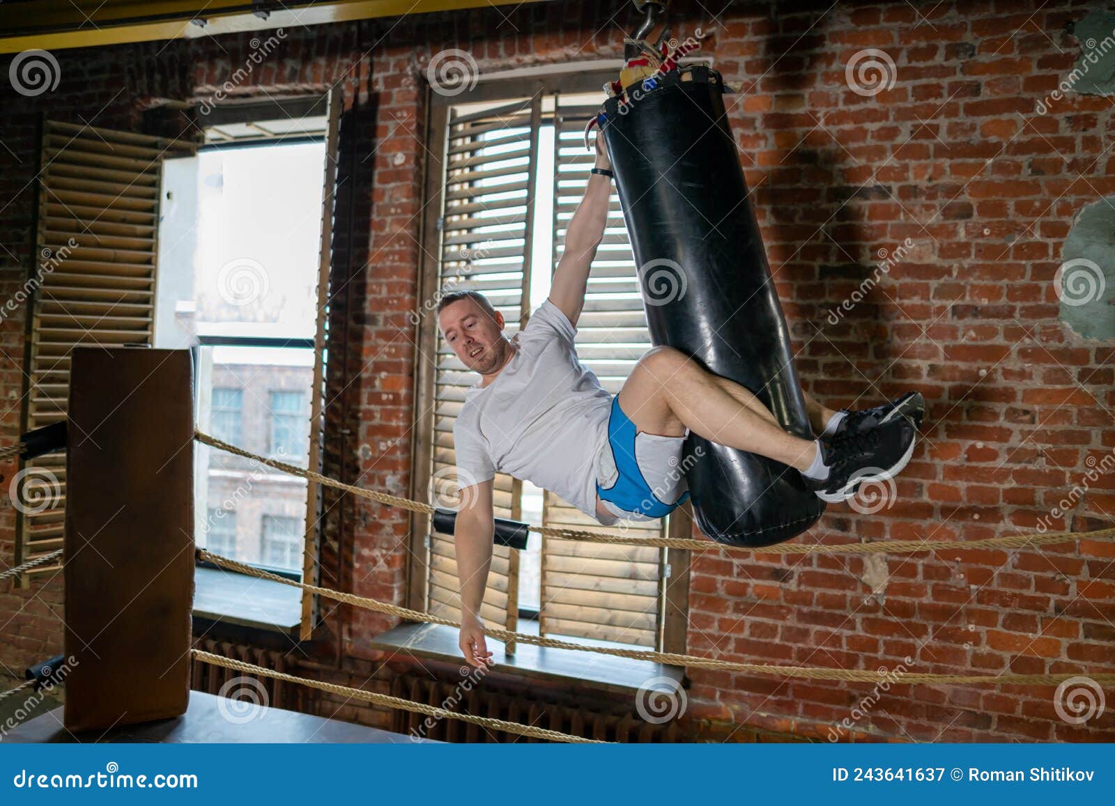 Boxer Hangs on a Punching Bag in a Boxing Ring. Stock Image - Image of ...