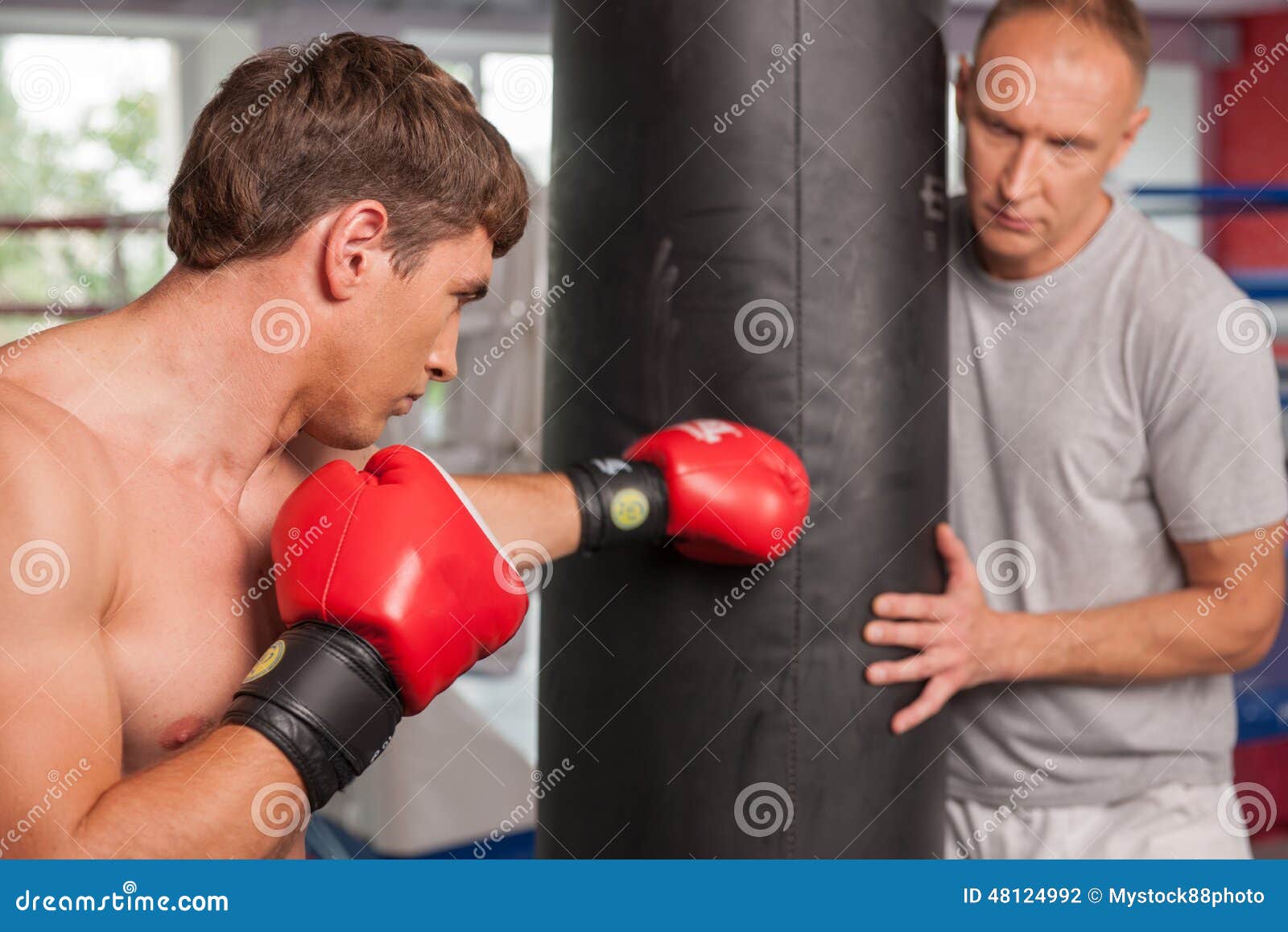 Boxer and His Coach Doing Some Punching with Bag. Stock Photo - Image ...