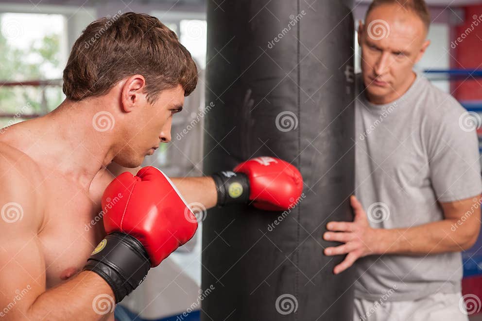 Boxer and His Coach Doing Some Punching with Bag. Stock Photo - Image ...