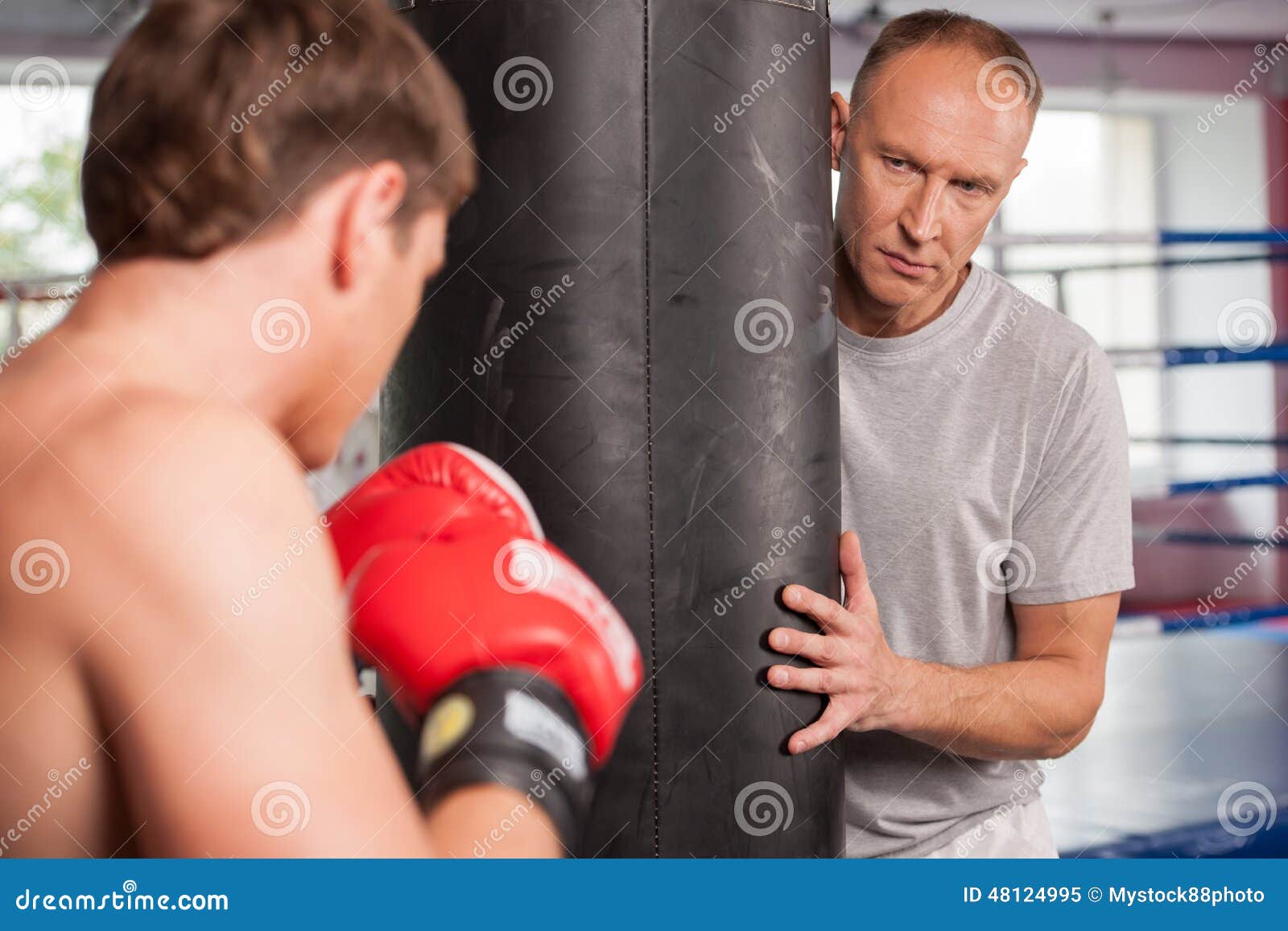 Boxer and His Coach Doing Some Punching with Bag. Stock Image - Image ...