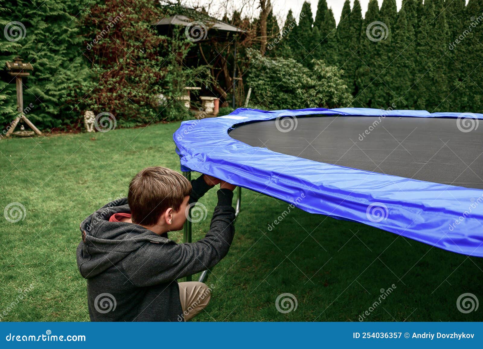 The Boy Assembles a New Trampoline and Stretches the Springs To Jump ...
