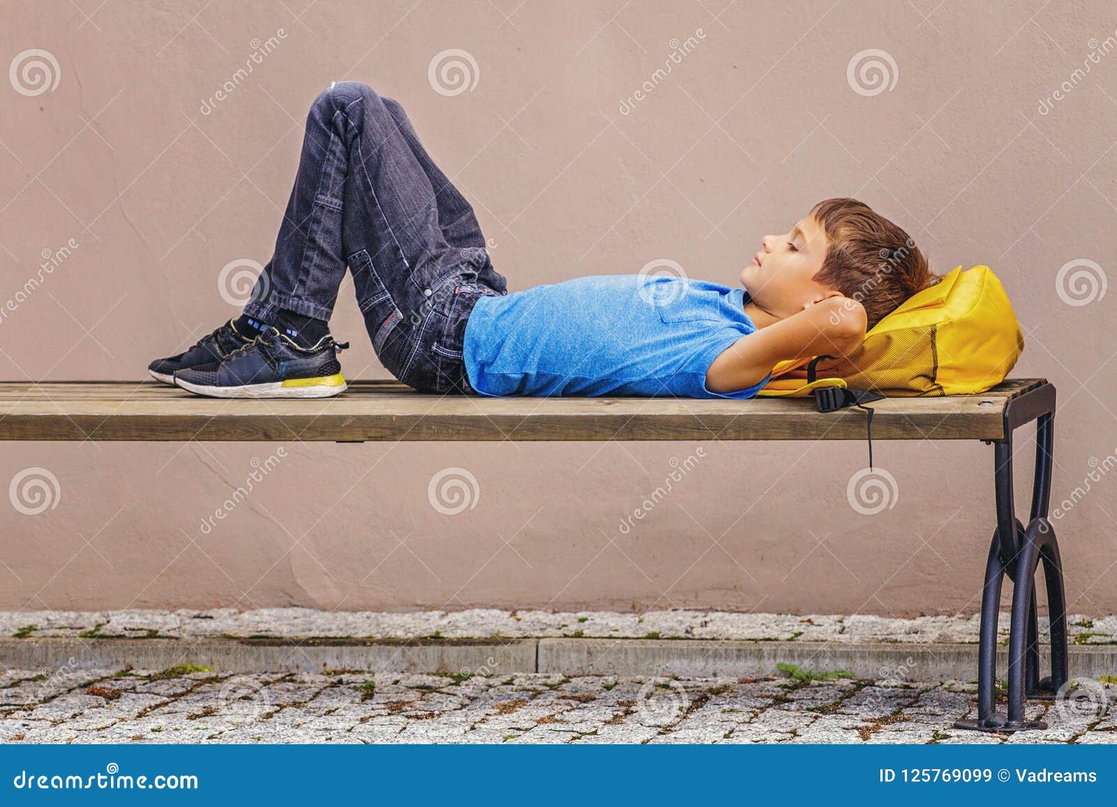 Boy with Backpack Under Head Lying on the Bench Outdoors Stock Image ...