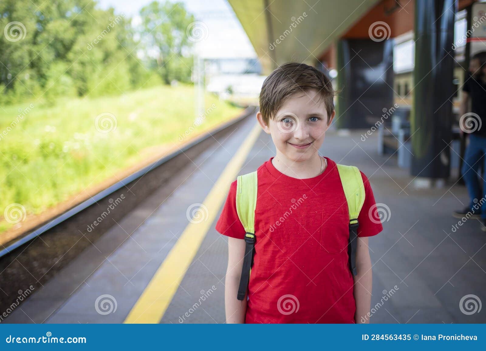 A Boy with a Backpack is Waiting for a Train, an Electric Train on a ...