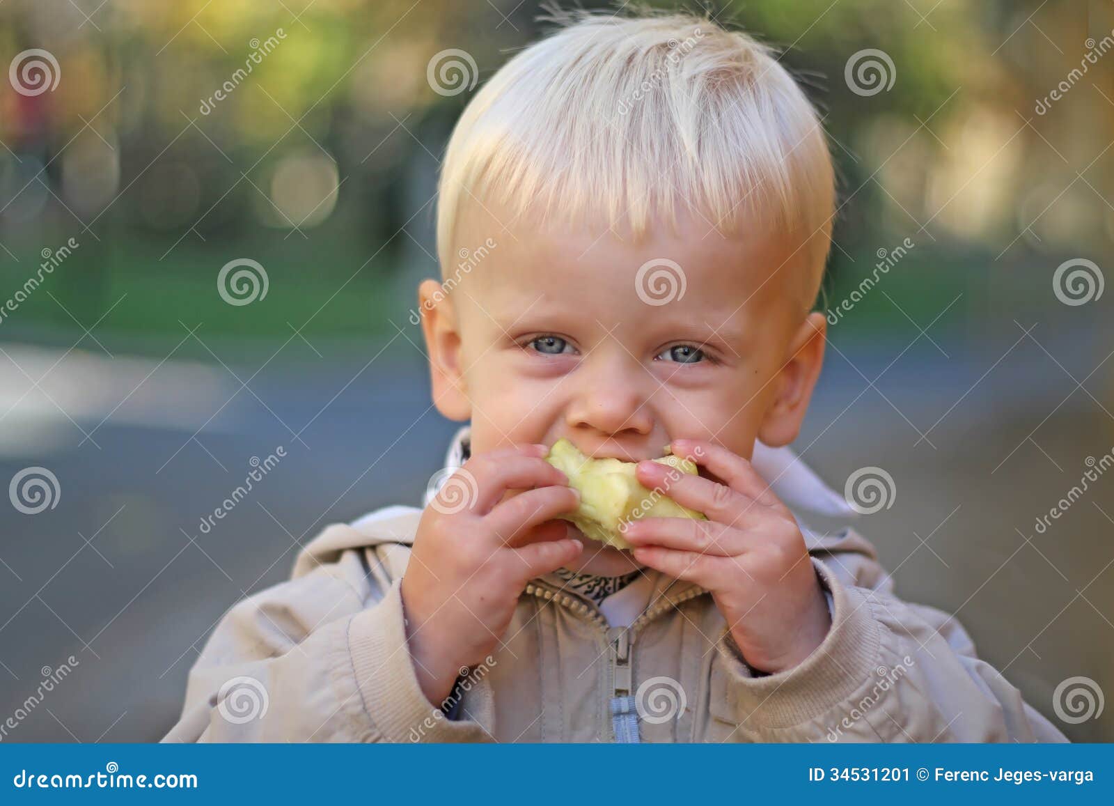 A boy bites into an apple stock image. Image of blond - 34531201