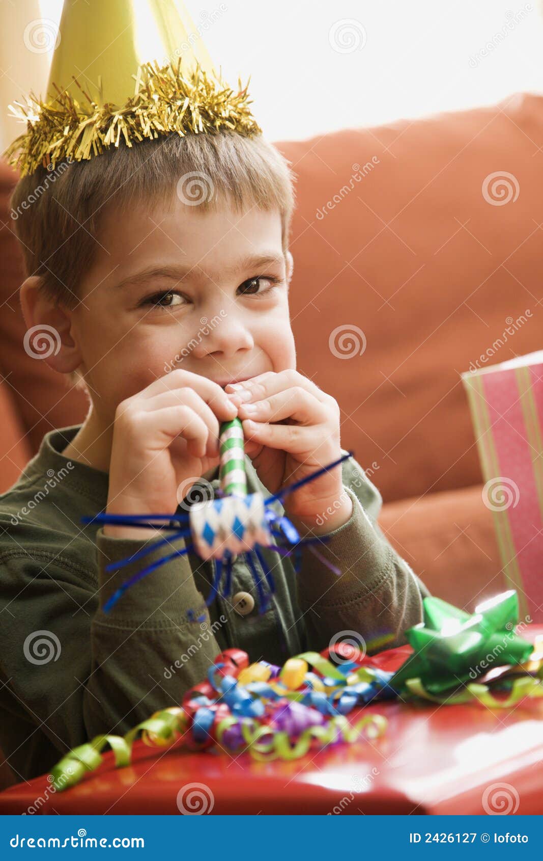 Boy blowing noisemaker. stock image. Image of smiling - 2426127