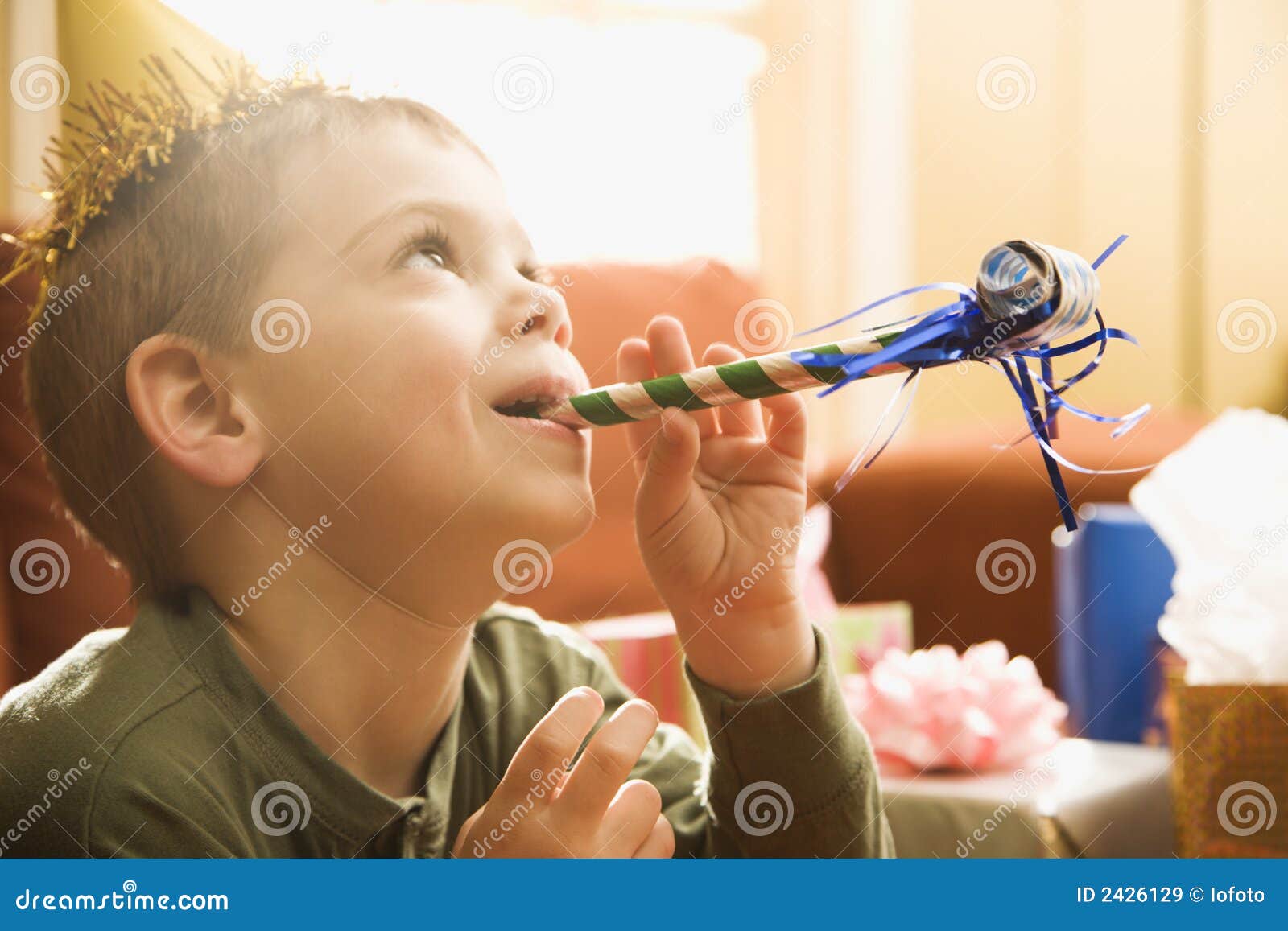 Boy blowing noisemaker. stock image. Image of color, male - 2426129
