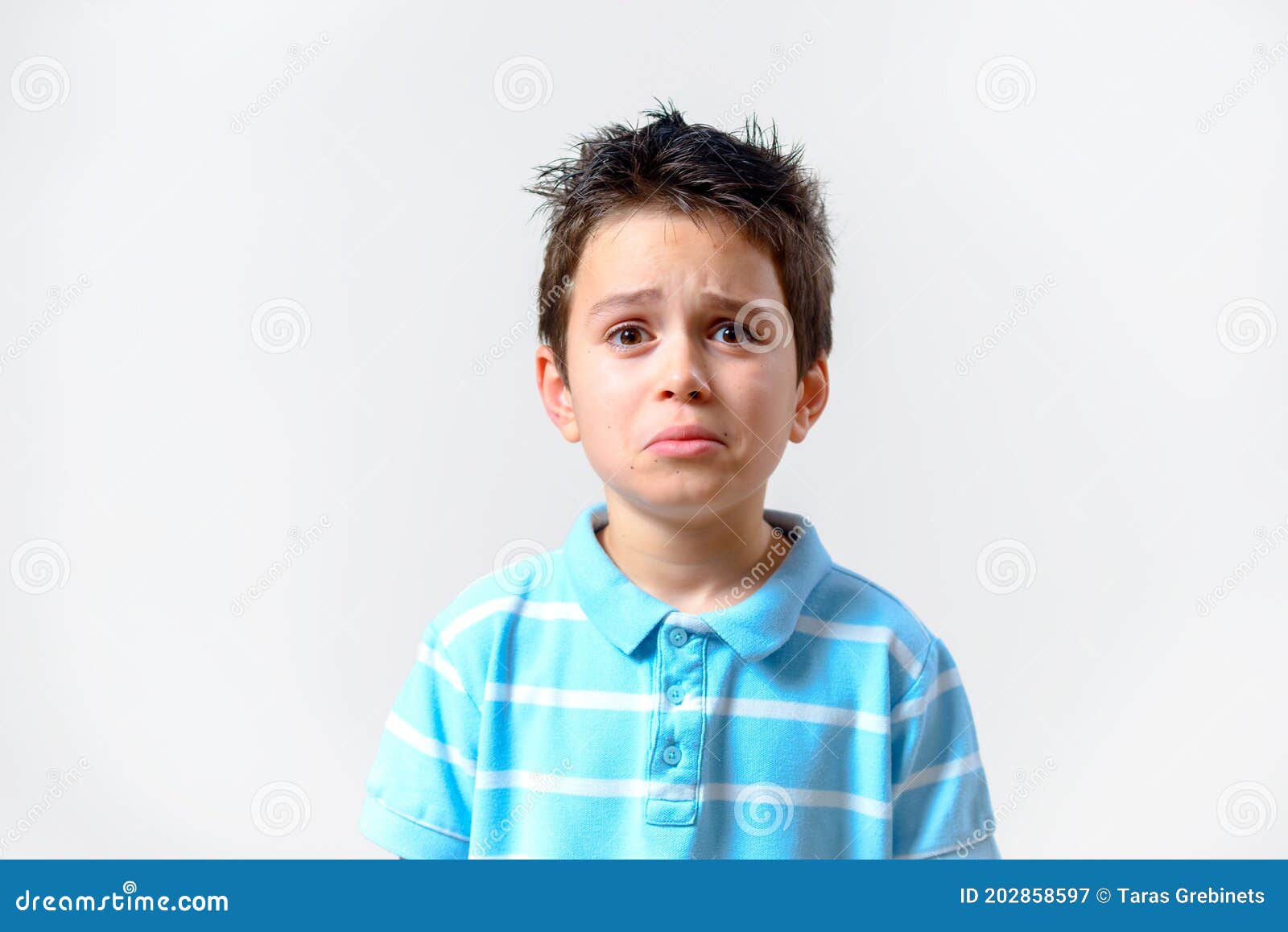 A Boy in a Blue T-shirt with a Disgruntled Expression Looks Squinted at ...