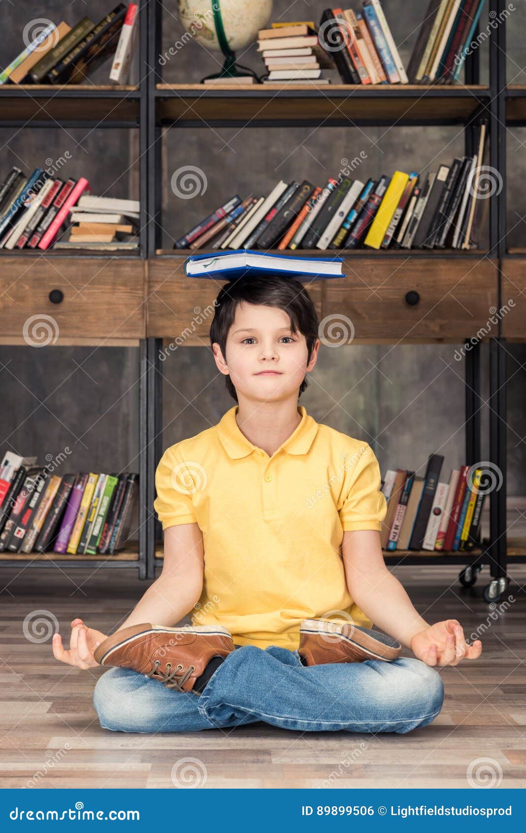 Boy with Book on Head Sitting in Lotus Pose Stock Photo - Image of book ...