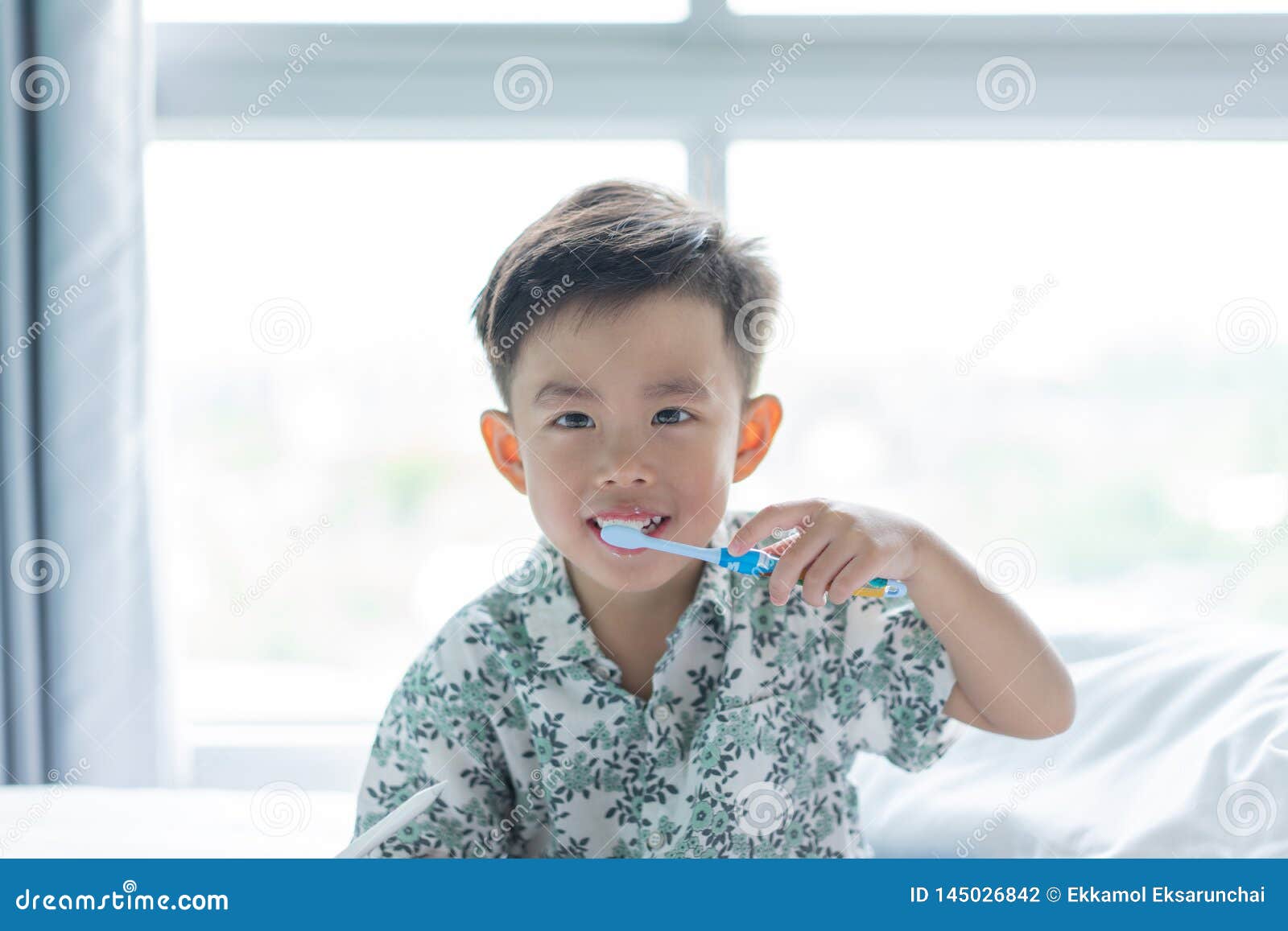 A Boy is Brushing His Teeth in the Morning on the Bed Stock Photo ...
