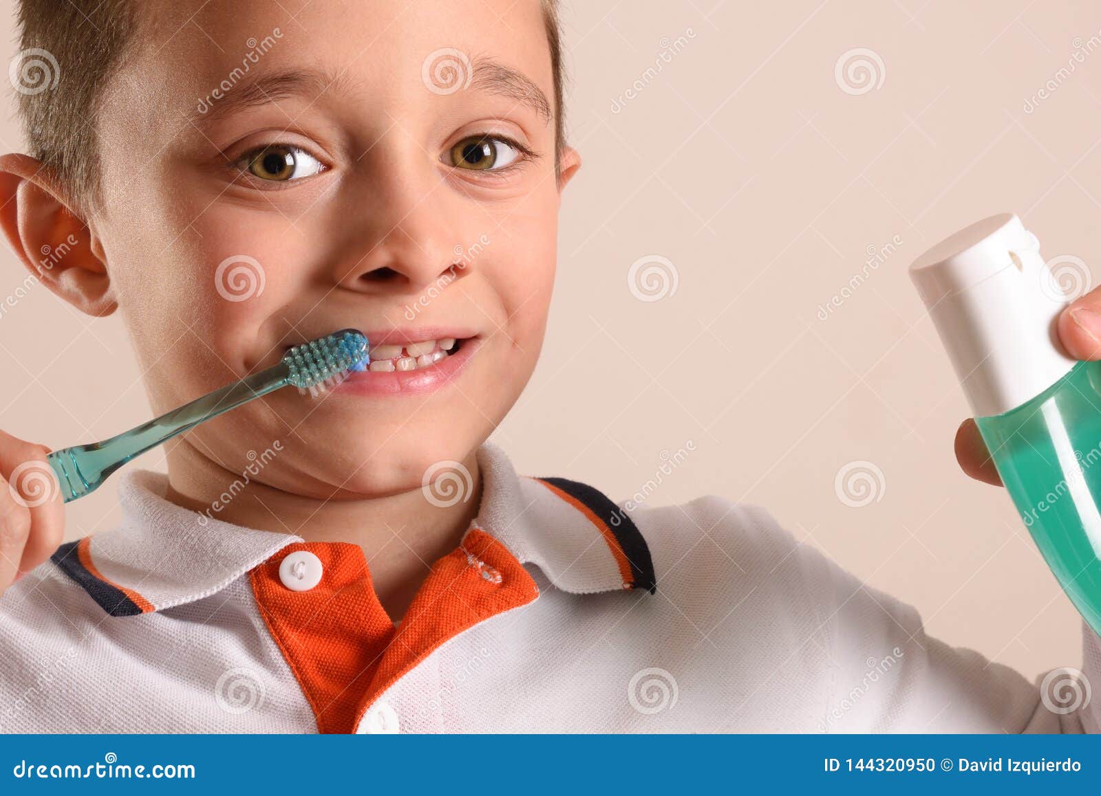 Boy Brushing Teeth with Toothbrush on Isolated Brown Stock Photo ...