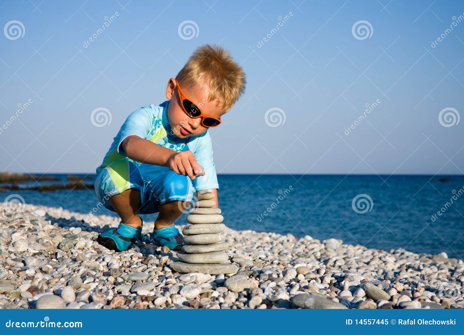 Boy building stone stack stock image. Image of building - 14557445