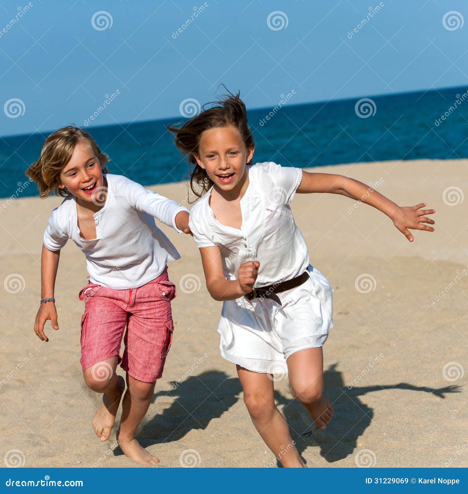 Boy chasing girl on beach. stock image. Image of activity - 31229069