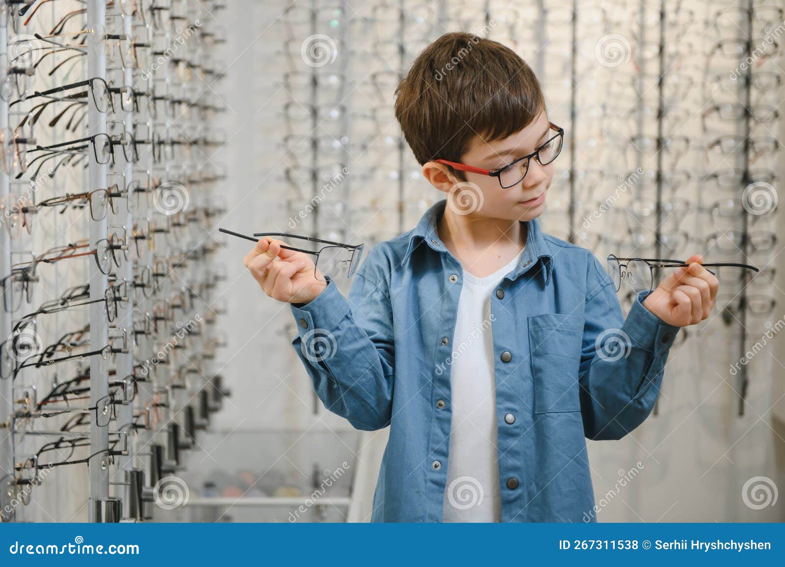 Boy Choosing Glasses in Optics Store. Stock Photo - Image of testing ...