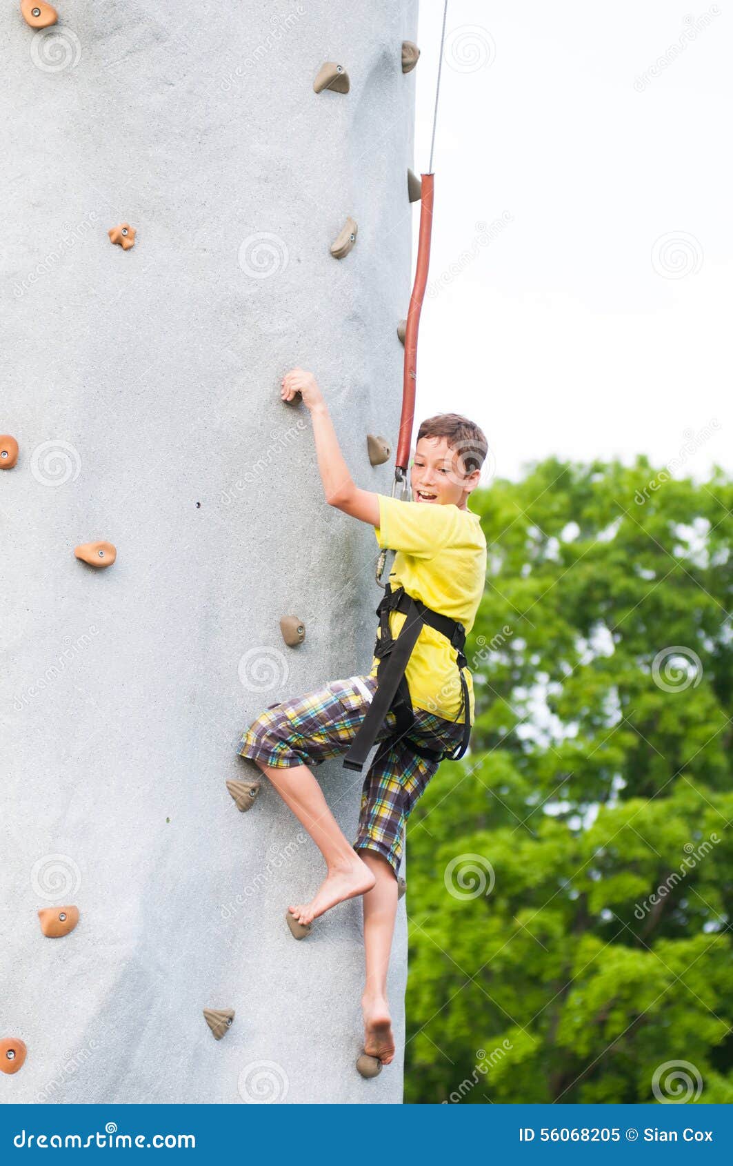 Boy climbing a rock wall stock image. Image of active - 56068205