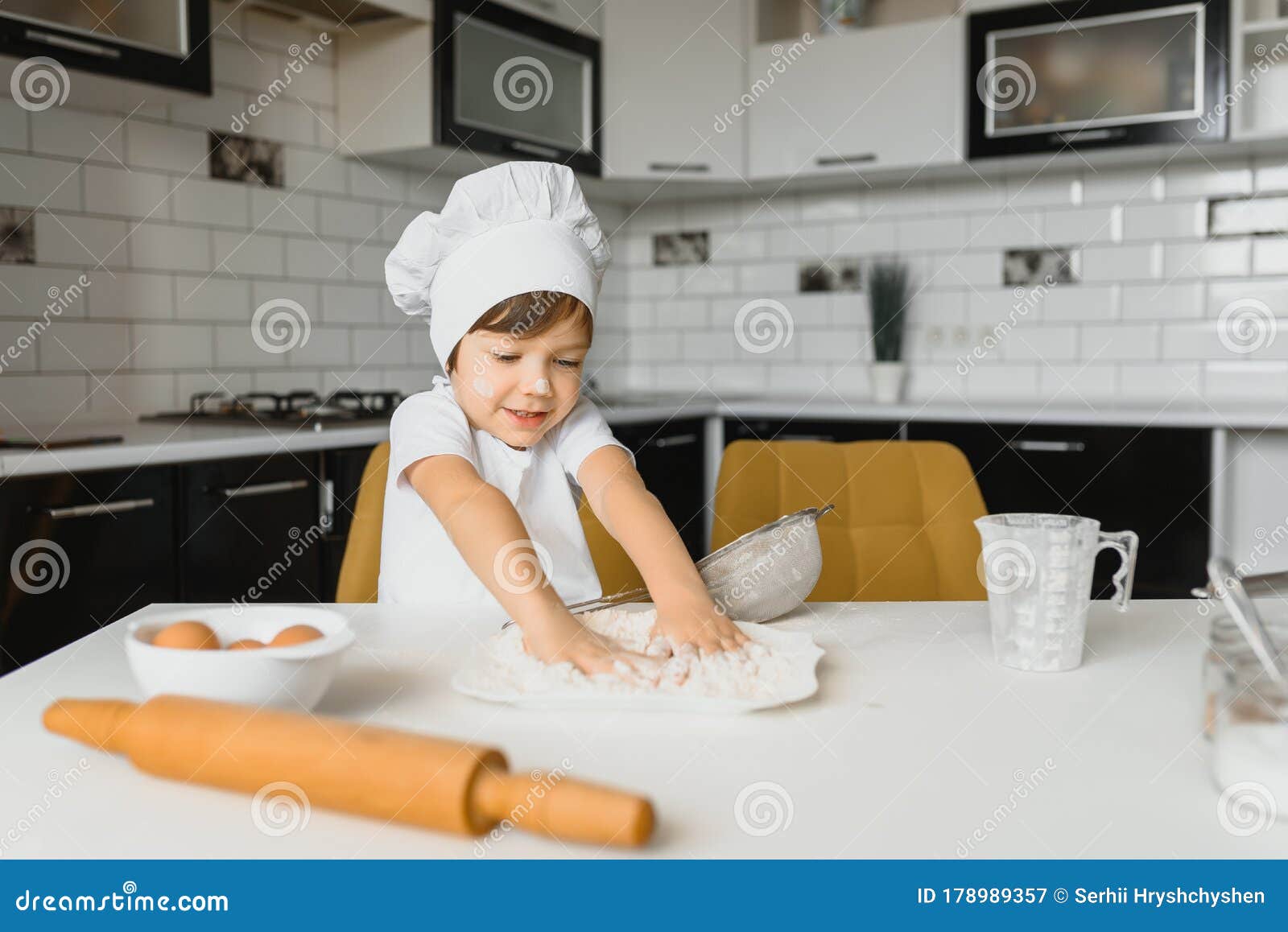 Boy in Cook Hat Sitting at a Kitchen Counter. Little Boy in Kitchen ...