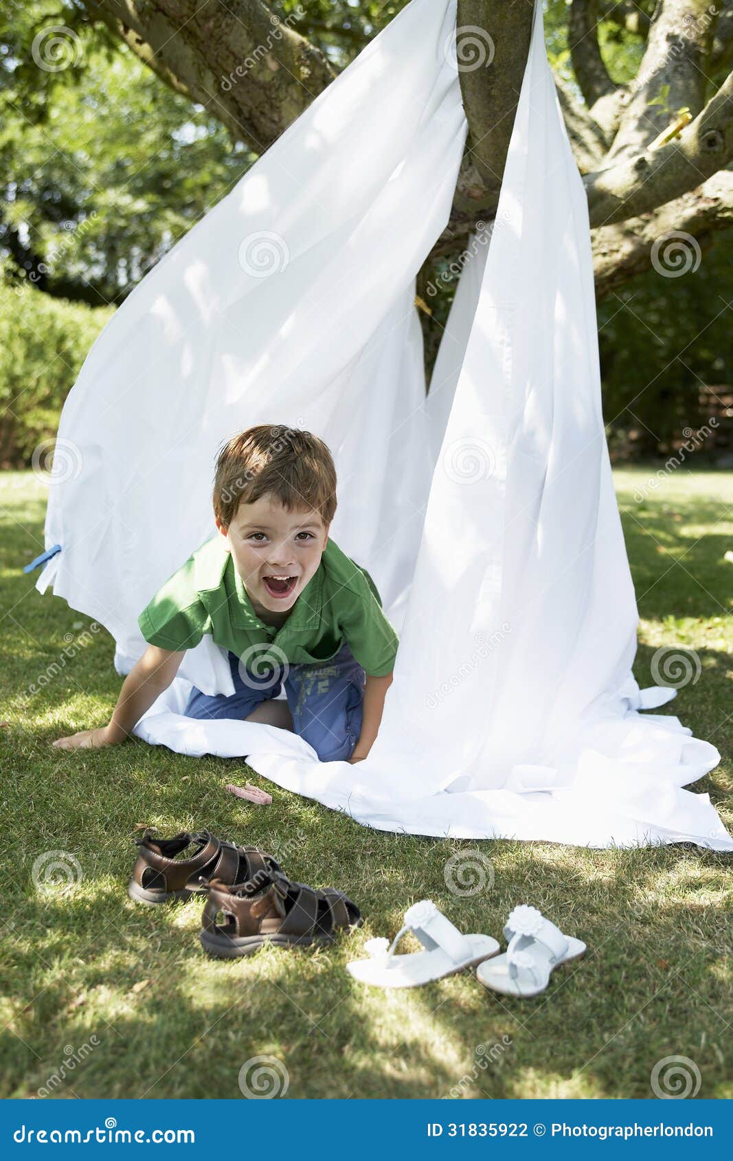Boy Crawling Out of Sheet Tent in Backyard Stock Photo - Image of park ...