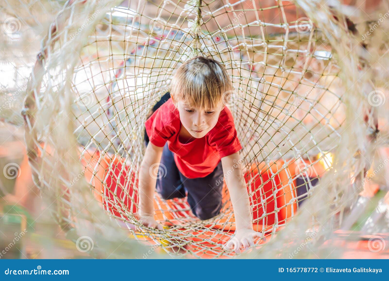 Boy Crawls on a Net in an Obstacle Course Stock Photo - Image of bridge ...