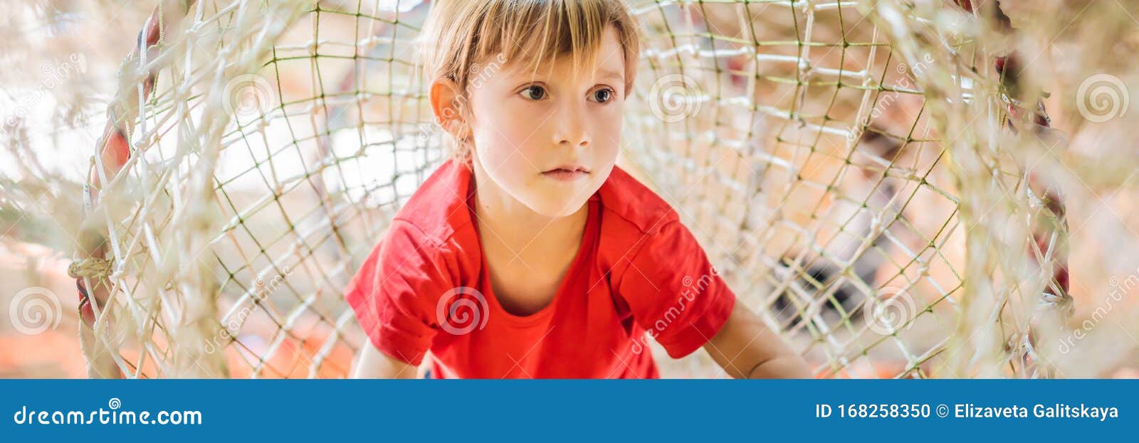 Boy Crawls on a Net in an Obstacle Course BANNER, LONG FORMAT Stock ...