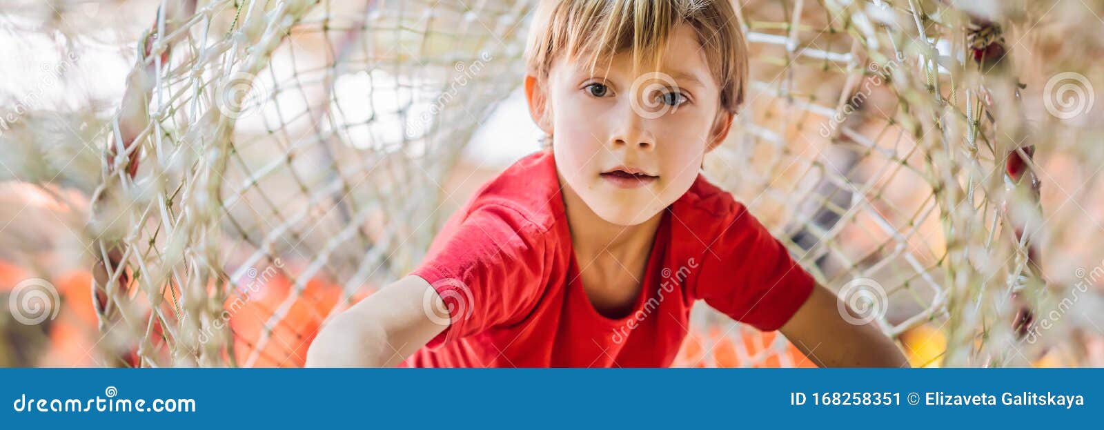 Boy Crawls on a Net in an Obstacle Course BANNER, LONG FORMAT Stock ...