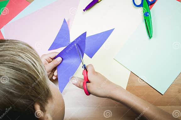 Boy Cutting Colored Paper with Scissors at the Table Stock Photo ...