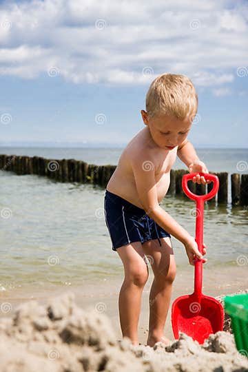 Boy dig in sand on beach stock photo. Image of summer - 9844158