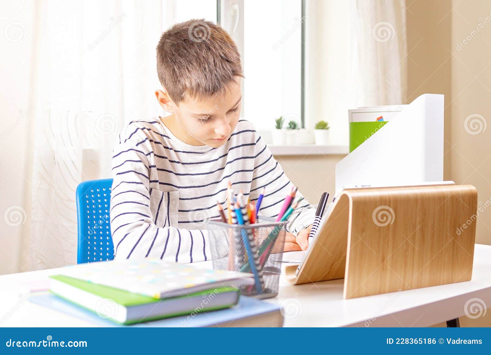 Boy with Digital Tablet Computer Writing on Notebook Doing Homework at ...