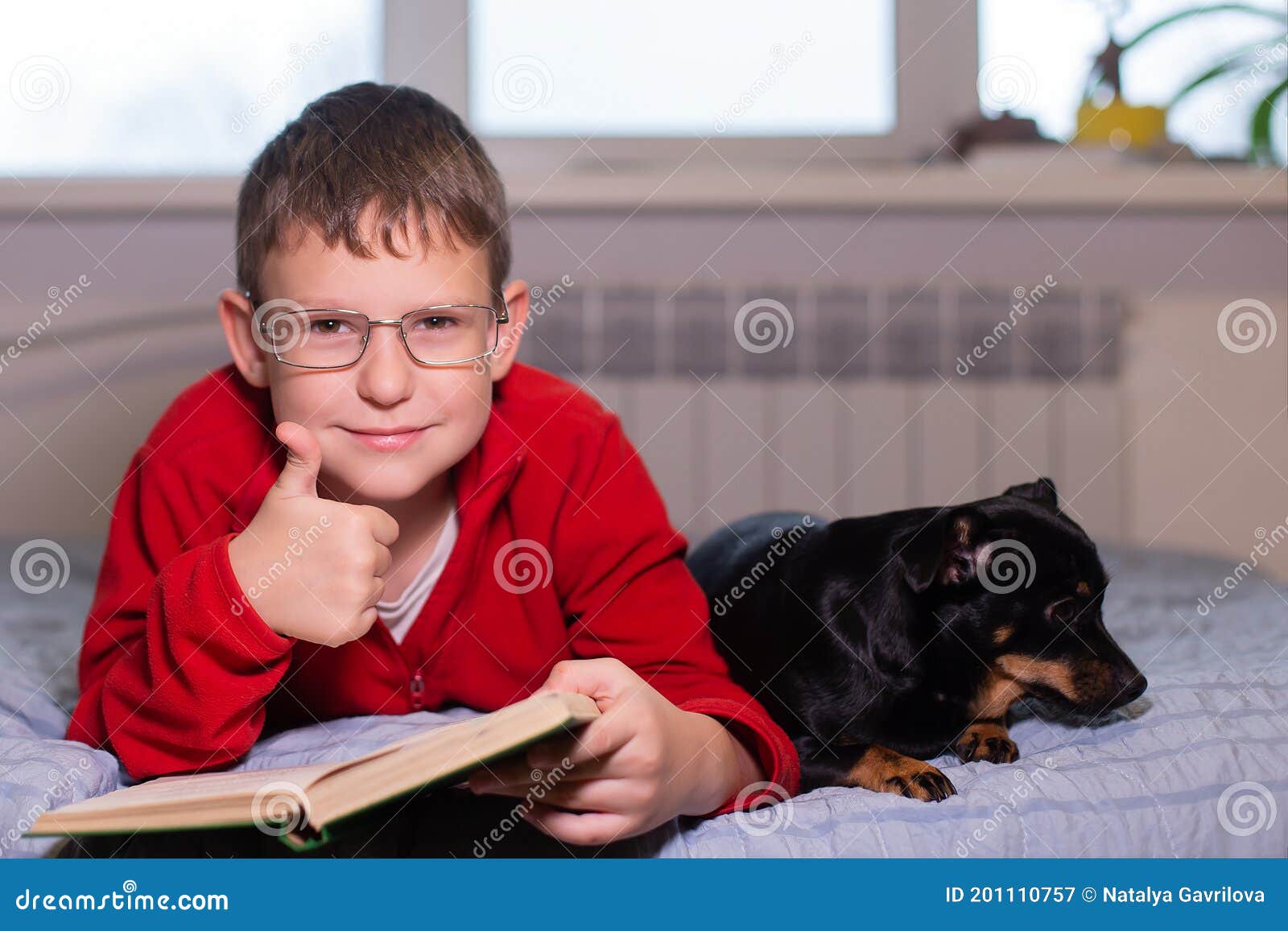 Boy with dog reads a book stock image. Image of express - 201110757
