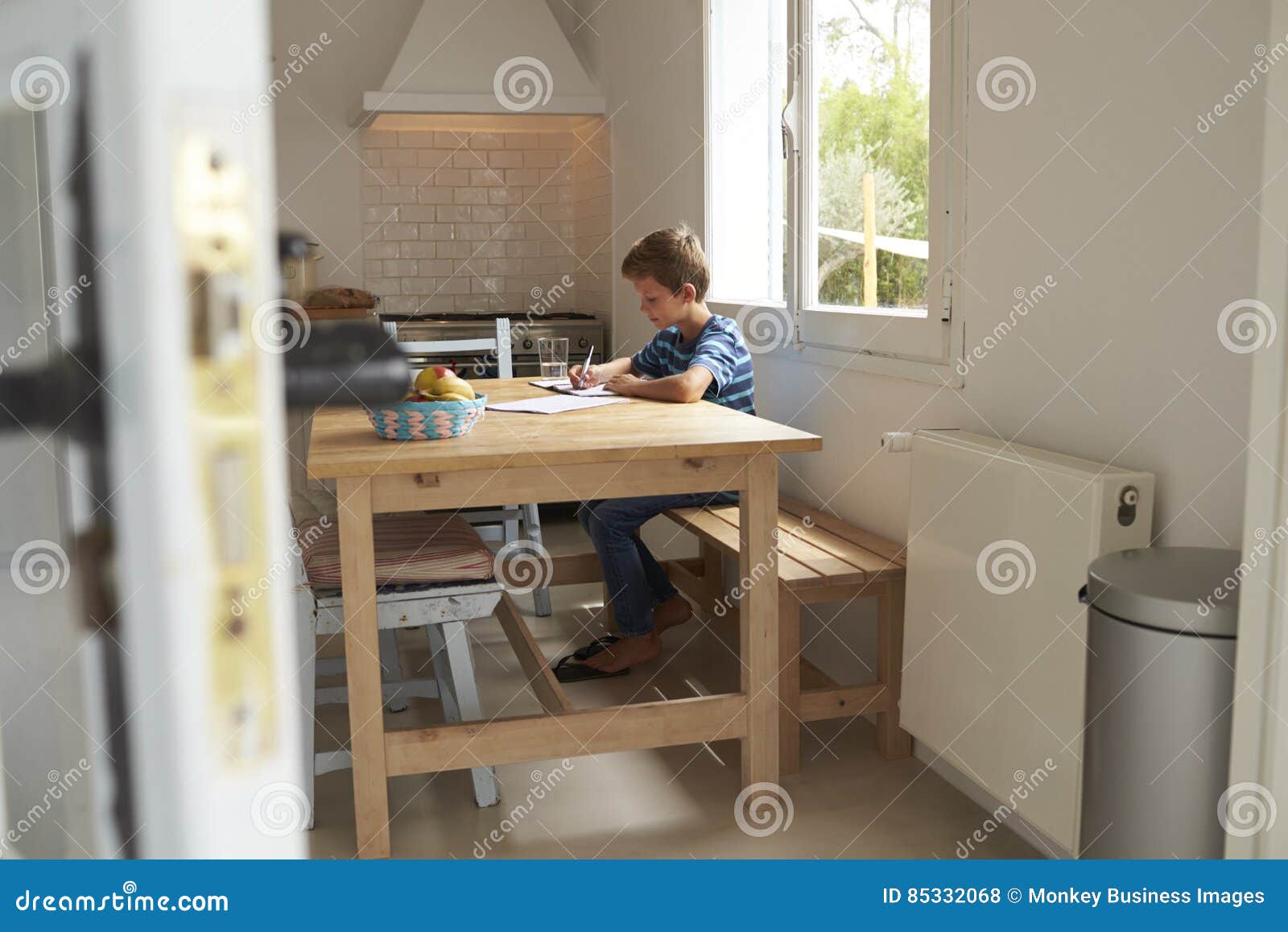 Boy Doing Homework Sitting at Kitchen Table Stock Photo - Image of ...