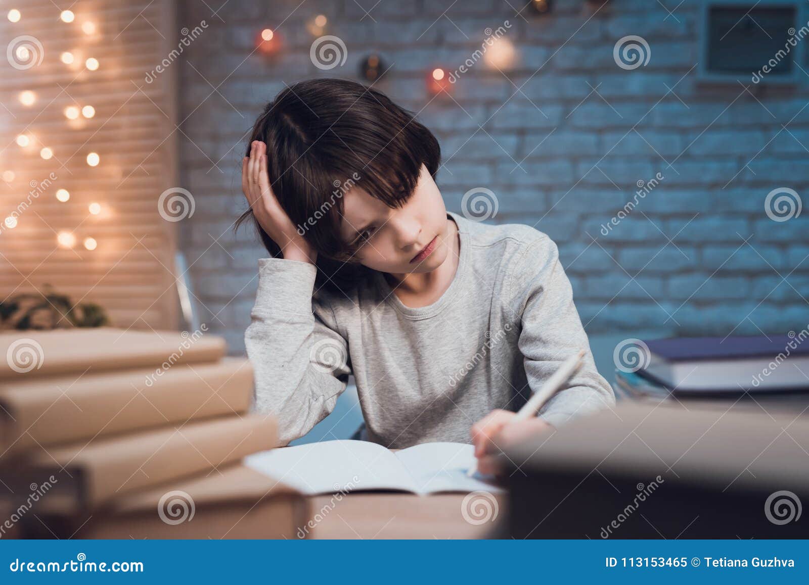Boy is Doing Homework Surrounded by Books at Night at Home. Stock Image ...