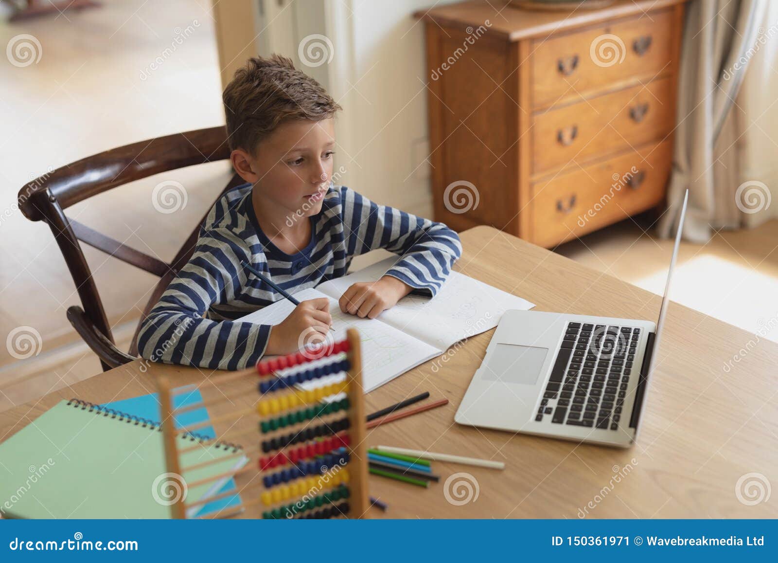 Boy Doing Homework at Table in a Comfortable Home Stock Image - Image ...