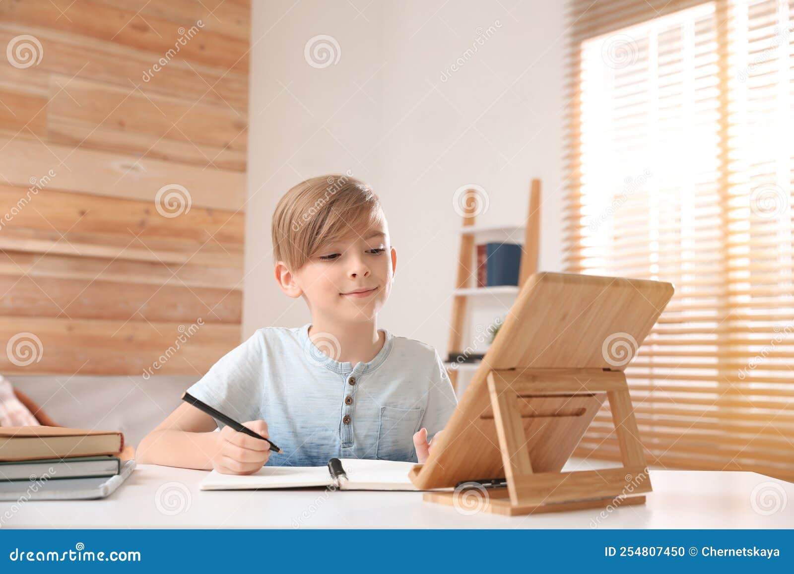 Boy Doing Homework with Tablet at Table Stock Photo - Image of computer ...