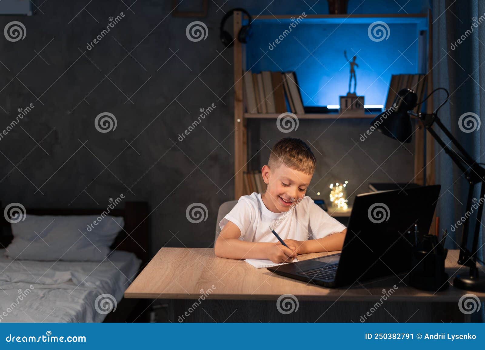 Boy is Doing Homework Using a Laptop Computer at His Bedroom Desk at ...