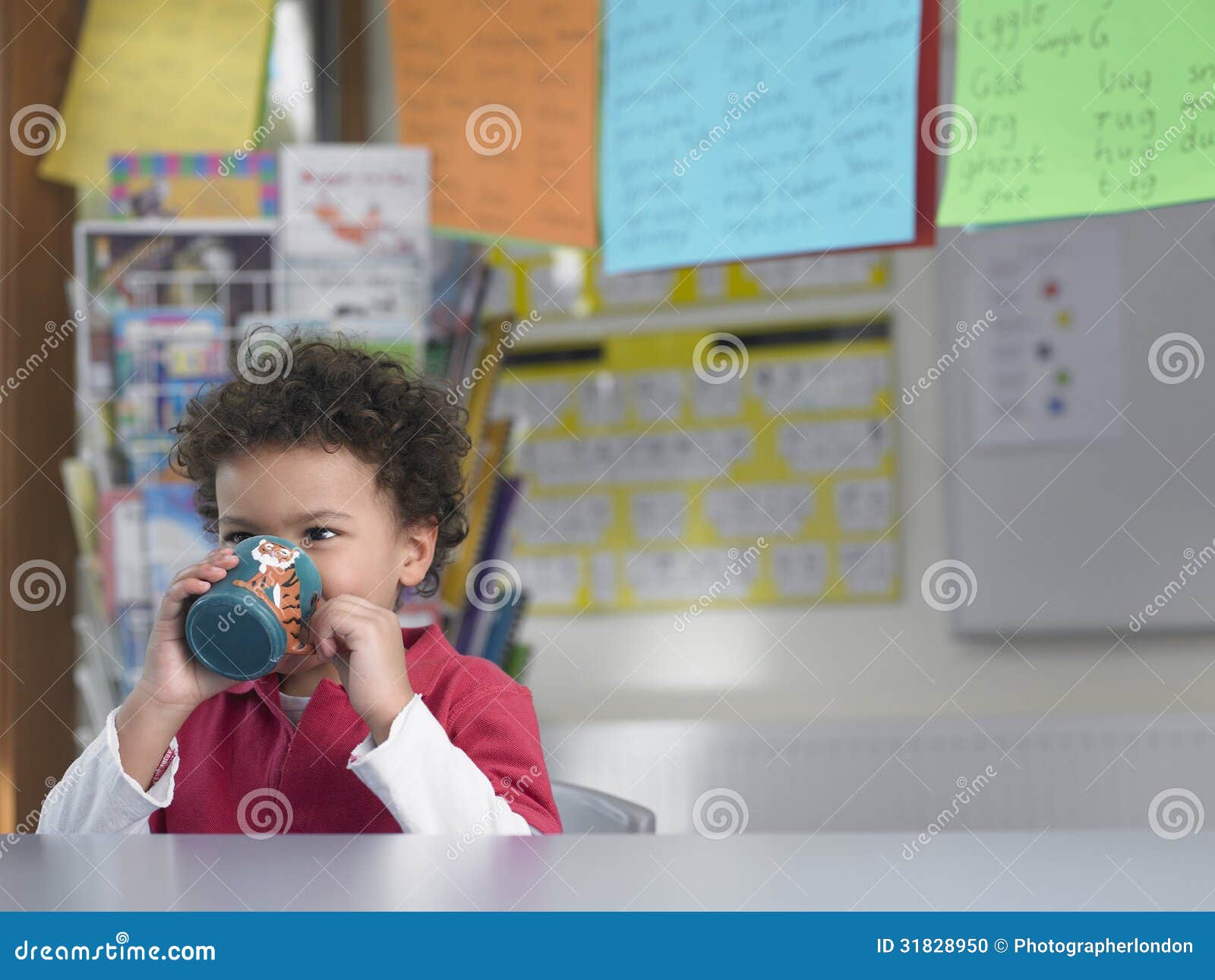 Boy Drinking from Cup in Classroom Stock Photo - Image of people, away ...