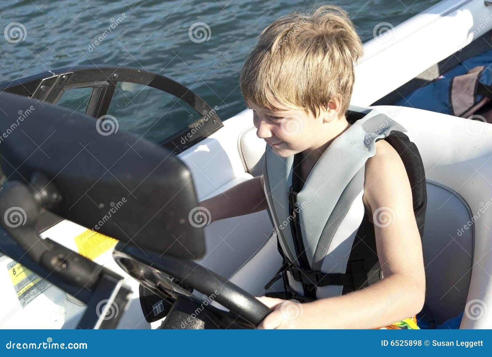 Boy Driving Ski Boat stock photo. Image of lifejacket - 6525898