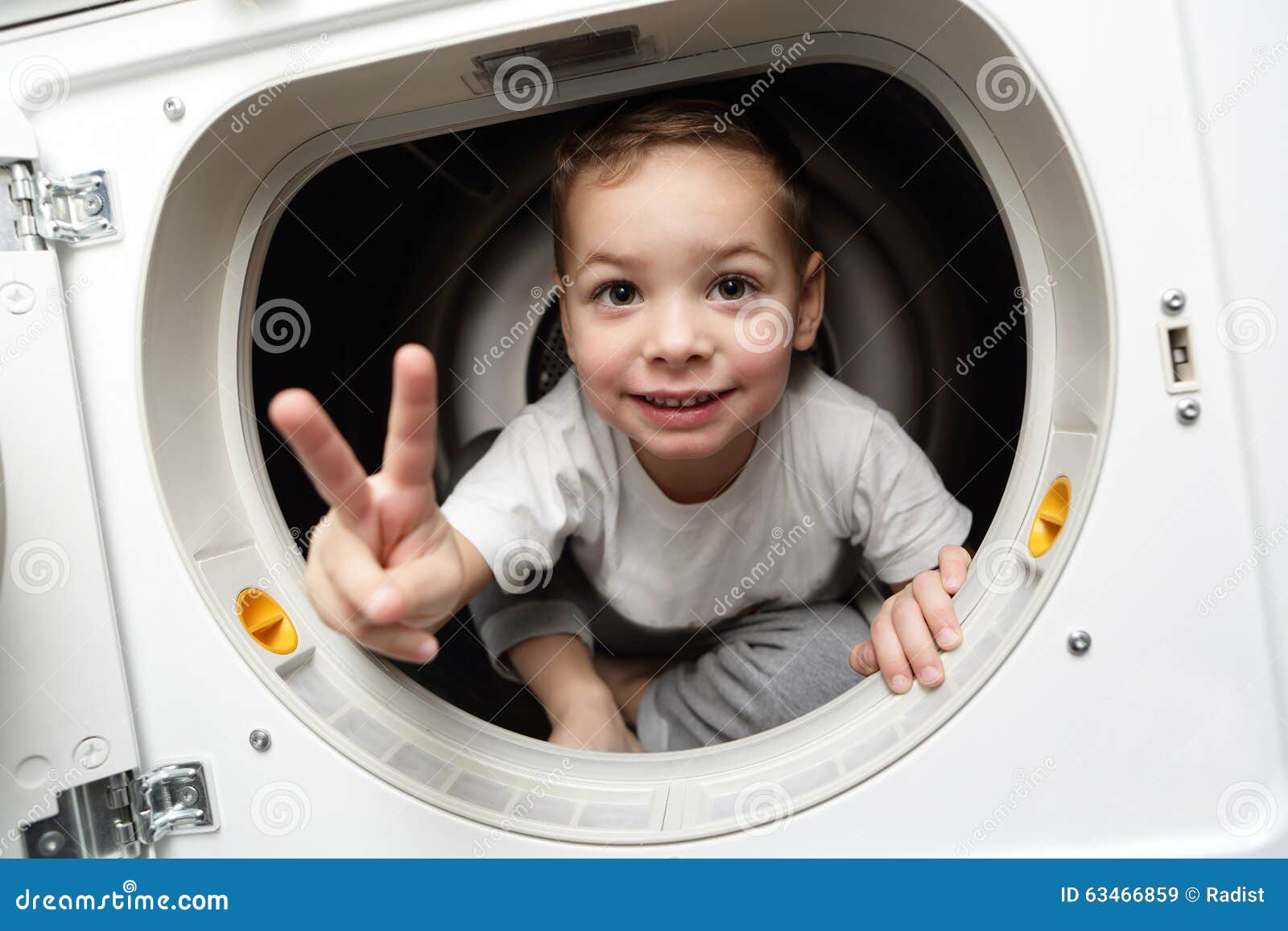 Boy in the dryer stock image. Image of casual, curiosity - 63466859