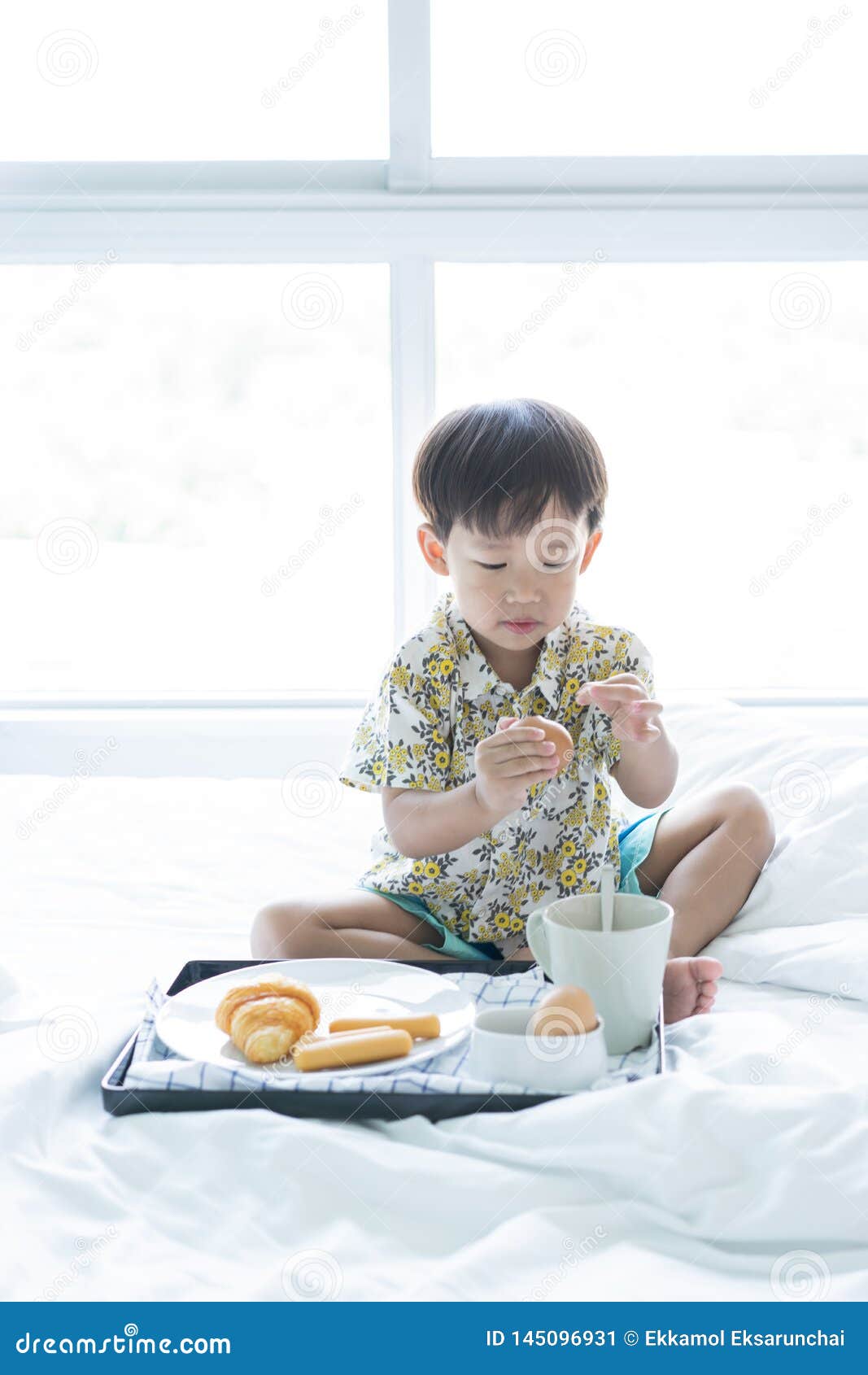Boy is Eating Breakfast on the Bed in the Morning Stock Image - Image ...