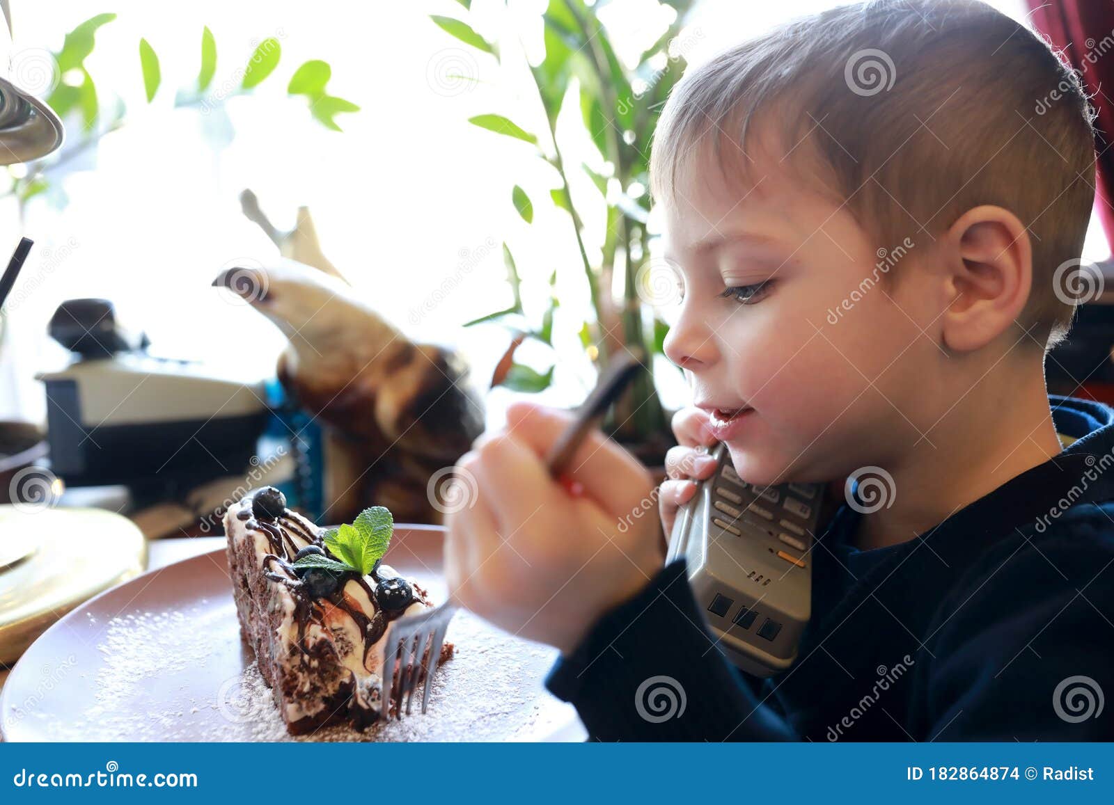 Boy eating cake in cafe stock photo. Image of chocolate - 182864874