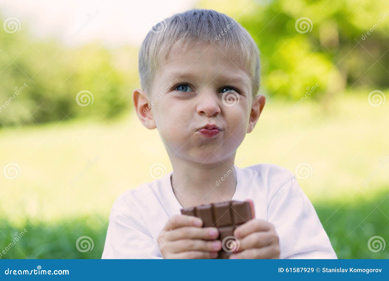 Boy Eating Chocolate Outdoors Stock Image - Image of park, face: 61587929