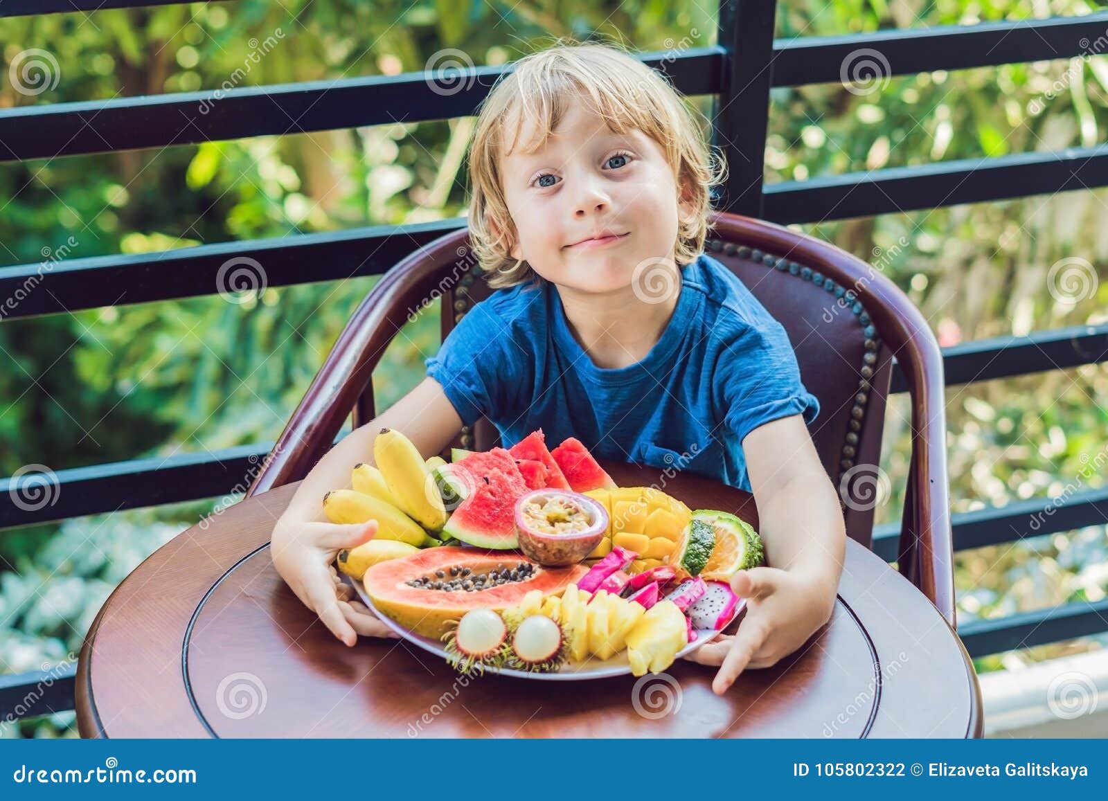 The Boy is Eating Different Fruits on the Terrace Stock Photo - Image ...