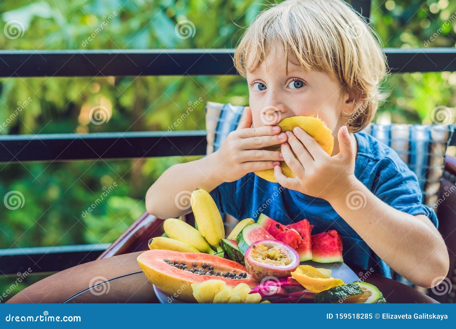 The Boy is Eating Different Fruits on the Terrace Stock Image - Image ...