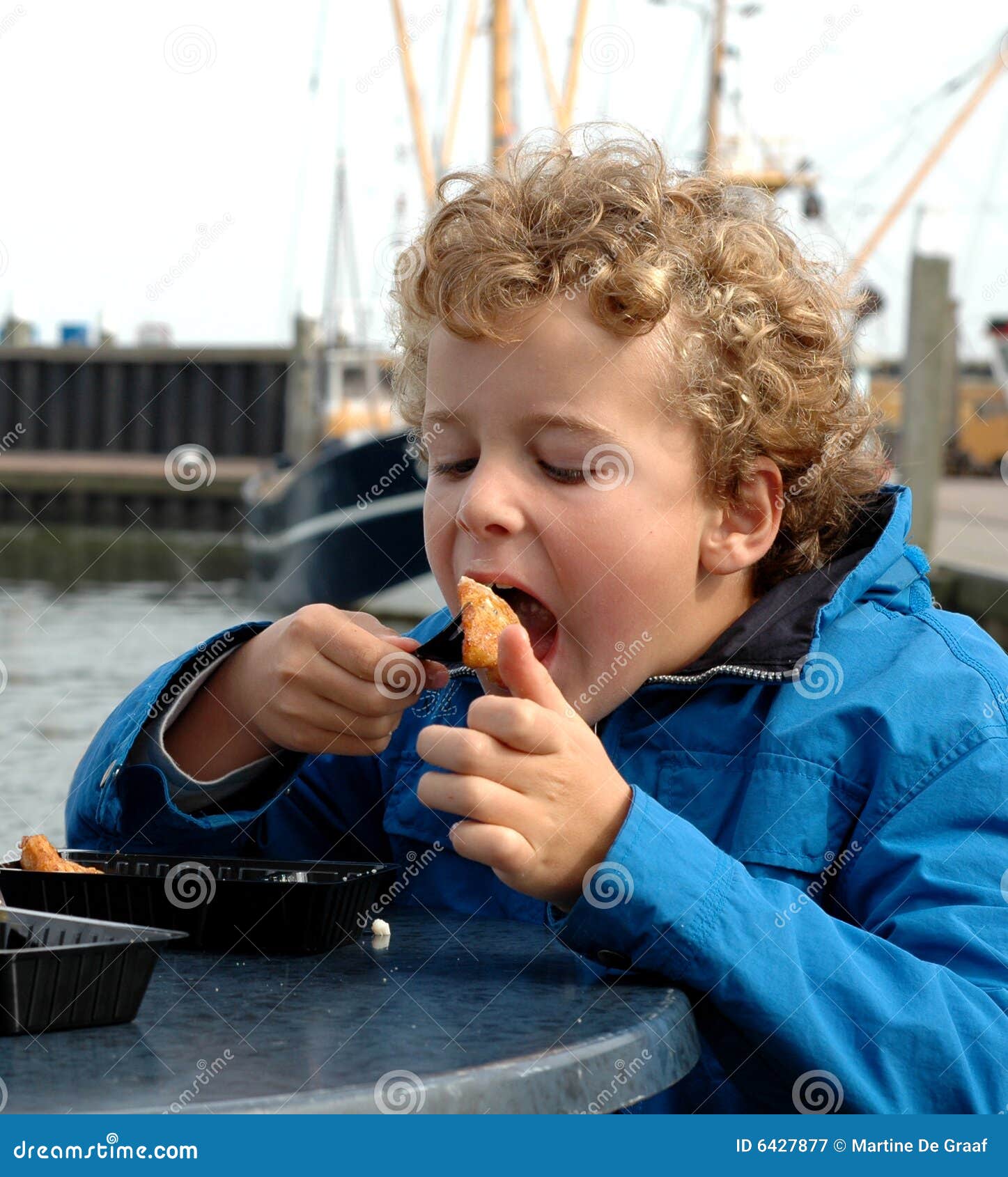 Boy eating Fish in Harbour stock image. Image of young - 6427877