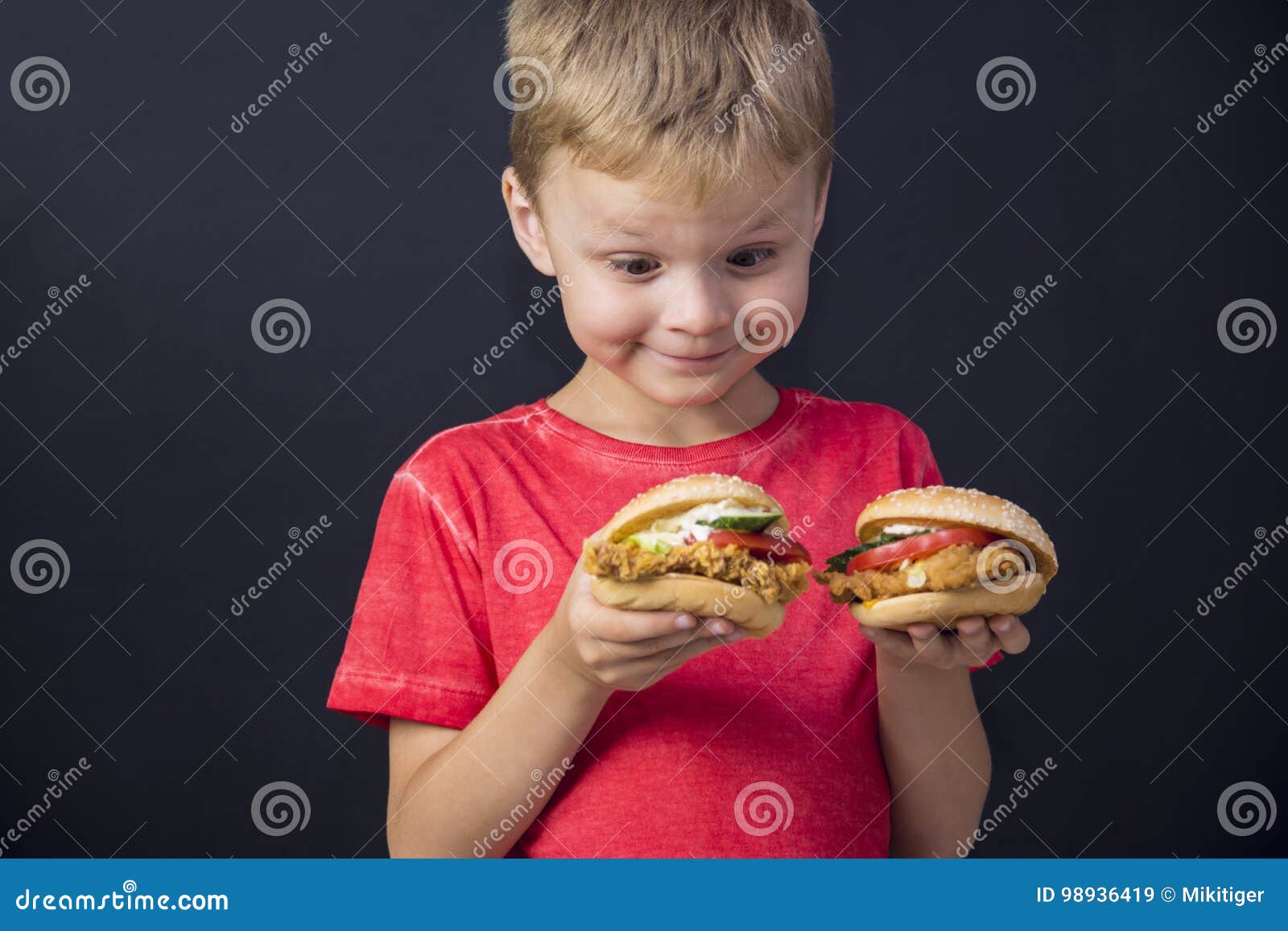 Boy eating a hamburger stock image. Image of appetite - 98936419